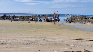 Perto da praia, espreguiçadeiras, guarda-sóis, toalhas de praia