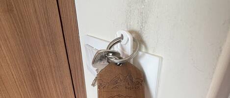 Uma porta de madeira com um chaveiro pendurado em uma parede branca.