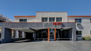 Uma entrada de hotel moderna com uma placa indicando "SIEGEL SELECT Extended-Stay".