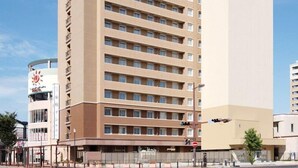 Um hotel de vários andares com fachada bege, várias varandas e uma placa indicando que é um hotel.