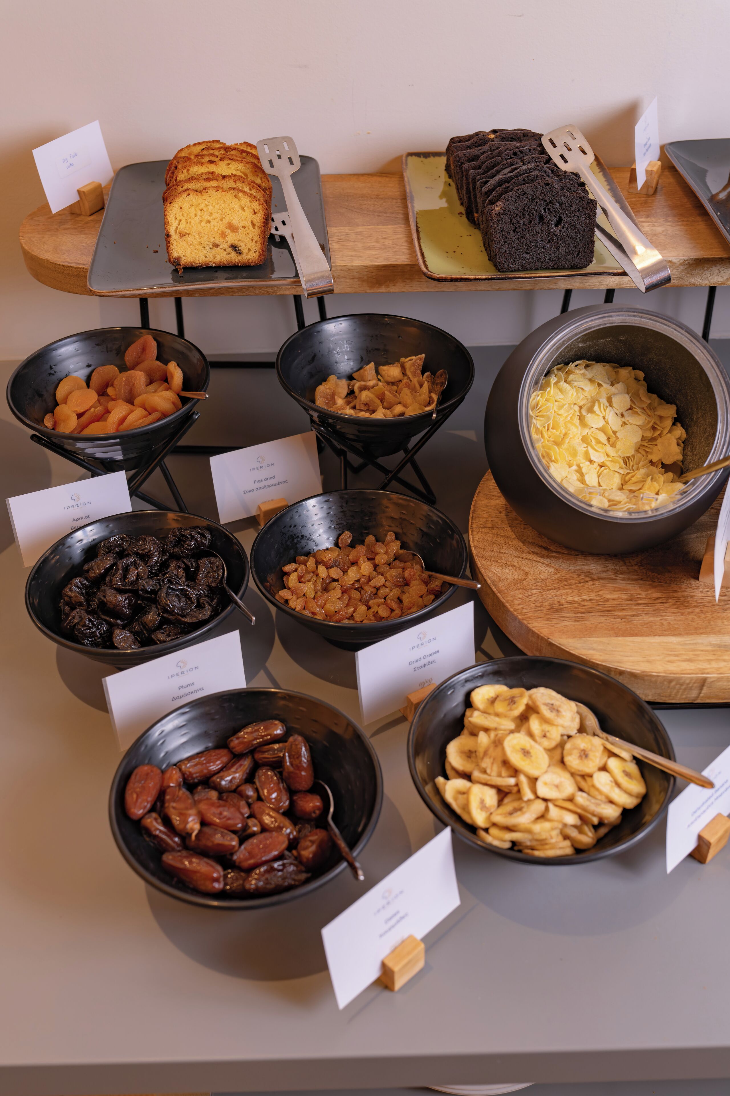 Buffet com diversas opções de comida, incluindo frutas, nozes e pão.