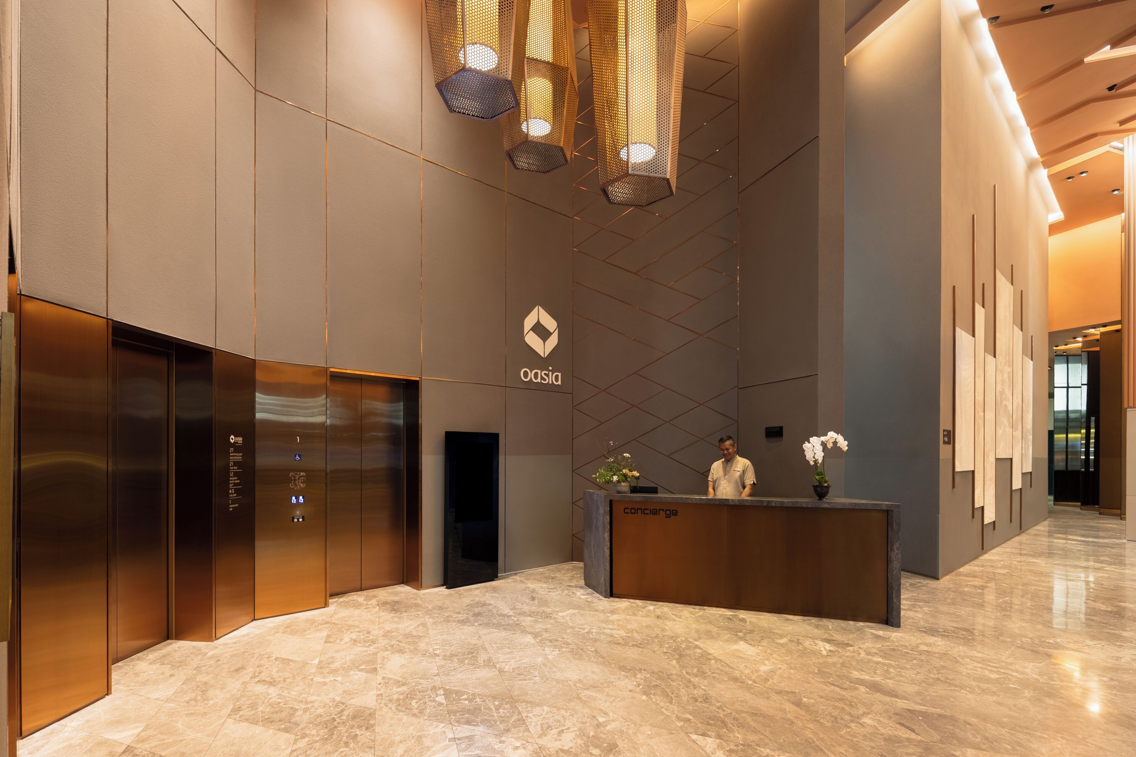 Um lobby moderno com balcão de atendimento, elevadores e um design de parede geométrico.