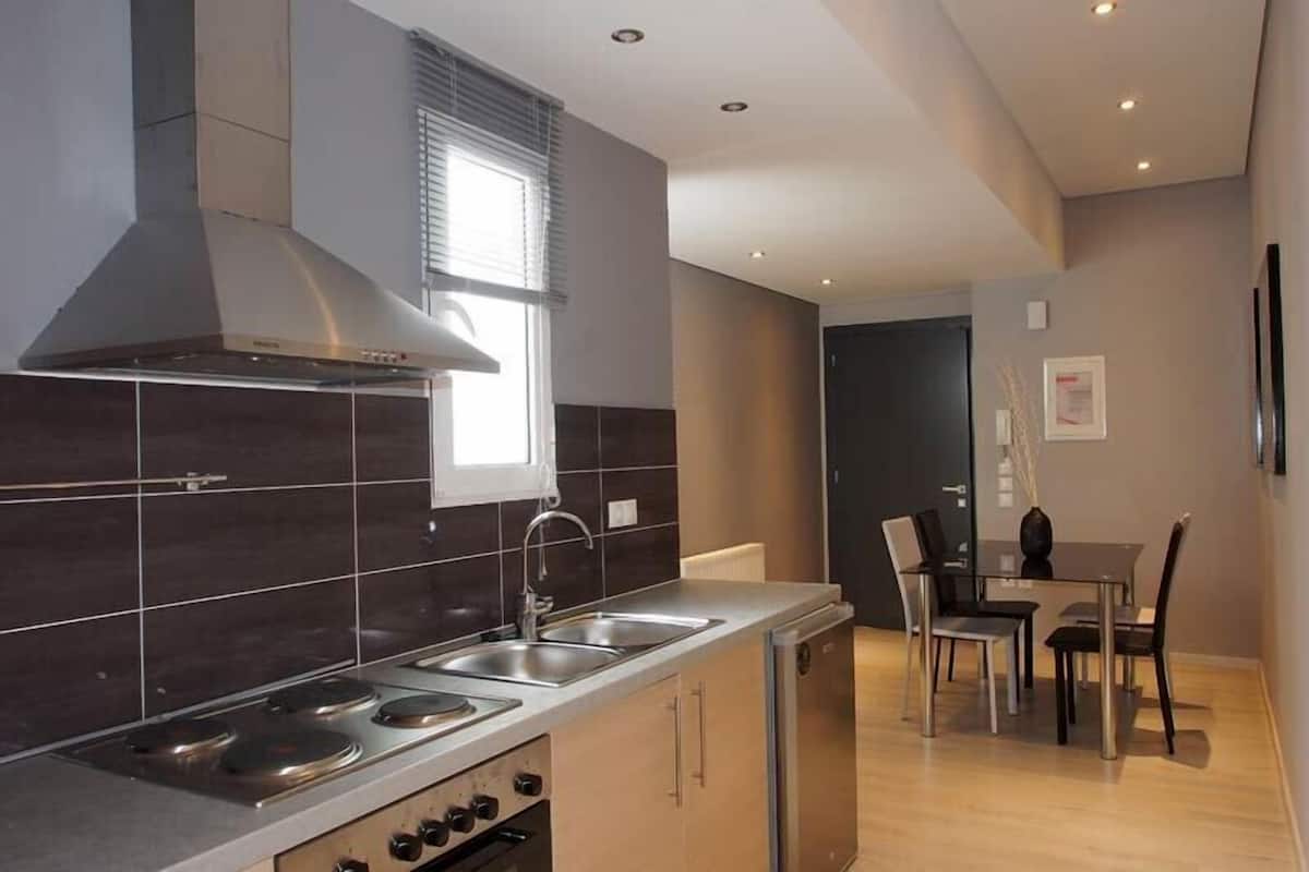 Cozinha moderna com fogão a gás, pia dupla e eletrodomésticos de aço inoxidável.