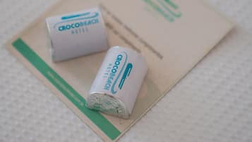 Dois artigos da marca Crocodile Beach Hotel sobre uma superfície texturizada.
