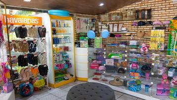 Uma loja com prateleiras cheias de chapéus, bolsas e outros acessórios.