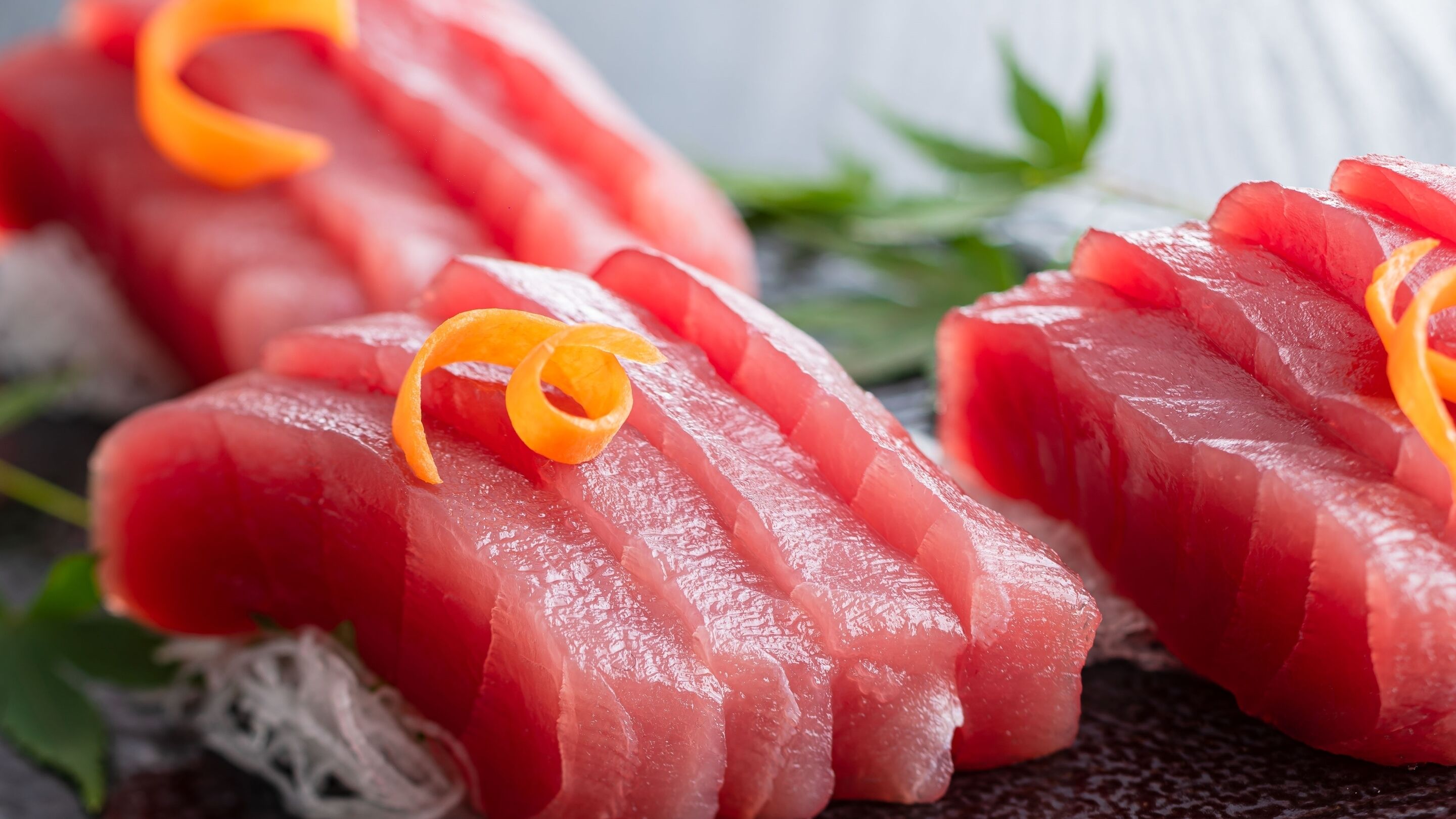 Close-up de sashimi com guarnição de raspas de laranja.