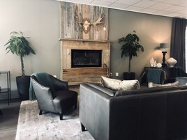 Uma sala de estar moderna com lareira, sofás de couro e plantas em vasos.
