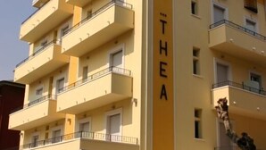 Um hotel com vários andares, varandas e uma placa com a inscrição