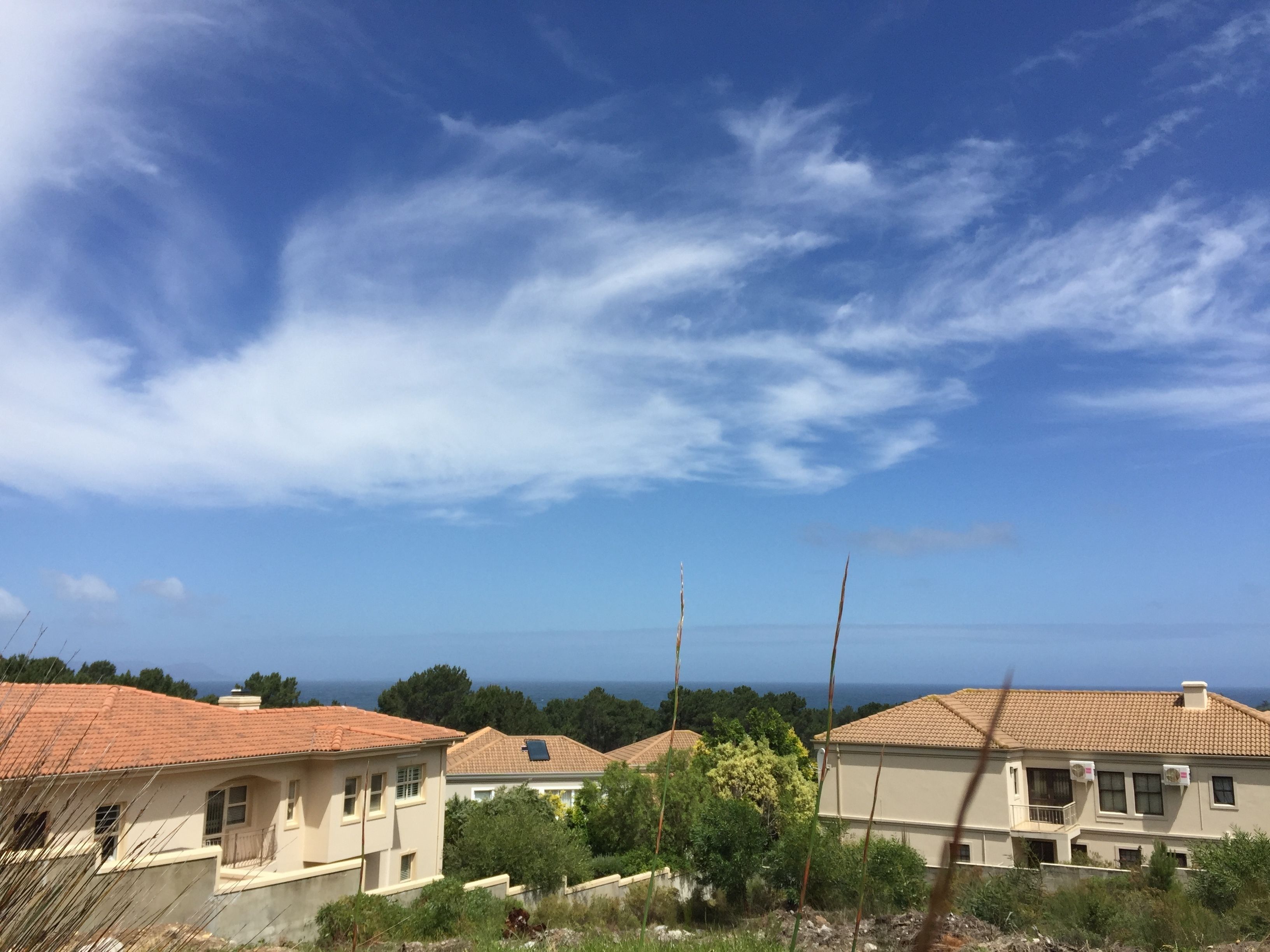 Zona residencial com casas de telhado ladrilhado e céu claro.