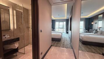 Quarto de hotel com banheiro, cama e vista para a cidade.