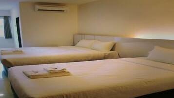 Quarto de hotel com duas camas, cada uma com uma toalha dobrada.