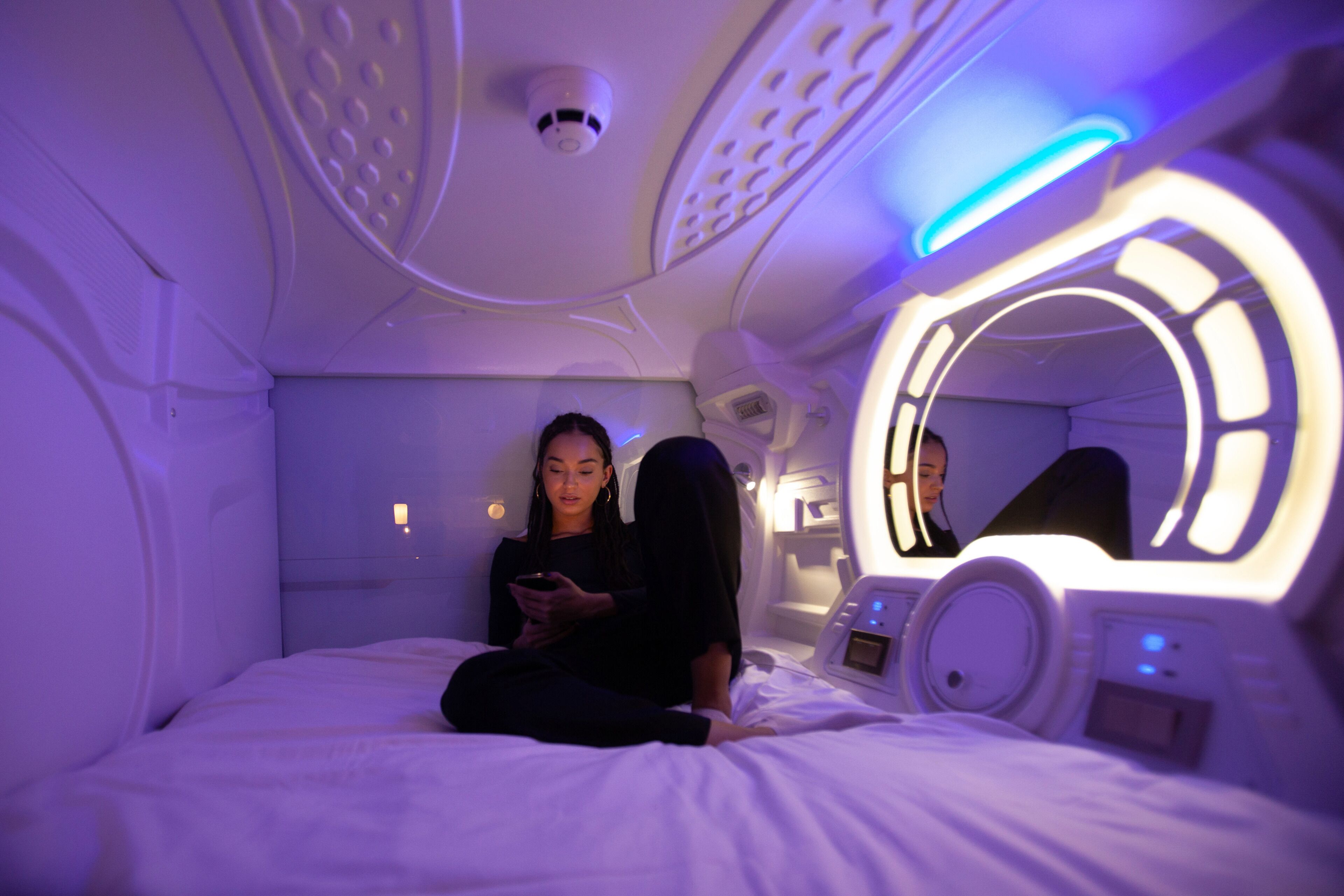 Quarto com cama, espelho e painel de controle.
