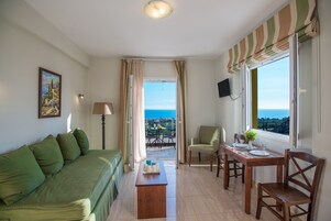Suite Familiar, vista para o mar | Sala de estar | TV de ecrã plano 