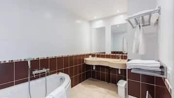 Uma casa de banho moderna com banheira, pia e espelho.