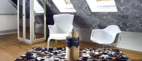 Quarto moderno estilo loft, com claraboias, uma janela grande e um tapete estampado.