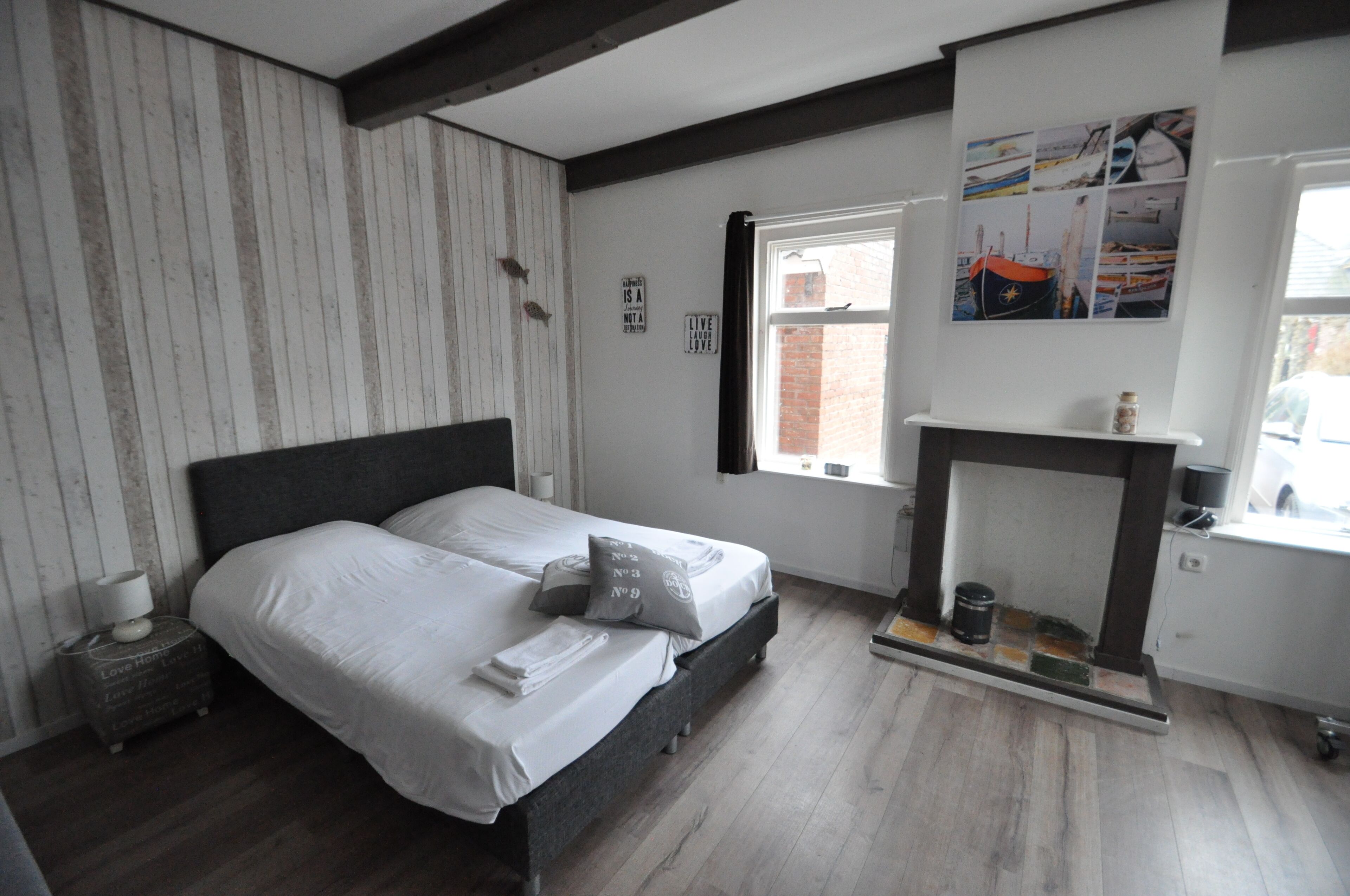 Quarto com cama, mesa de cabeceira, lareira e janela.