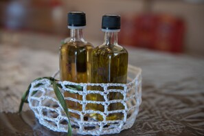 Duas garrafas numa cesta branca de crochê sobre uma superfície texturizada.