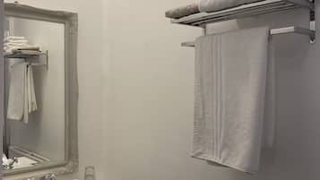 Casa de banho com lavatório branco, espelho, porta-toalhas e radiador.