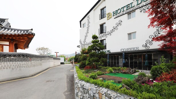 Um edifício em estilo tradicional coreano, com parede de pedra e um café moderno no andar térreo.