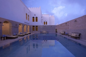 Uma área de piscina com espreguiçadeiras e spa.