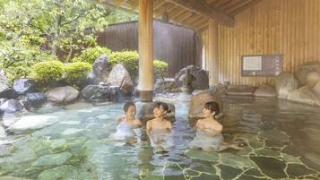Uma onsen japonesa tradicional com águas cristalinas, arquitetura em madeira e um jardim de pedras natural.