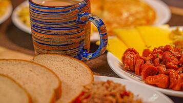 Uma mesa com diversas opções de pequeno-almoço, incluindo pão, ovos e uma chávena.