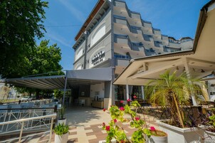 Hotel com design arquitetônico moderno, área de estar ao ar livre e plantas em vasos.