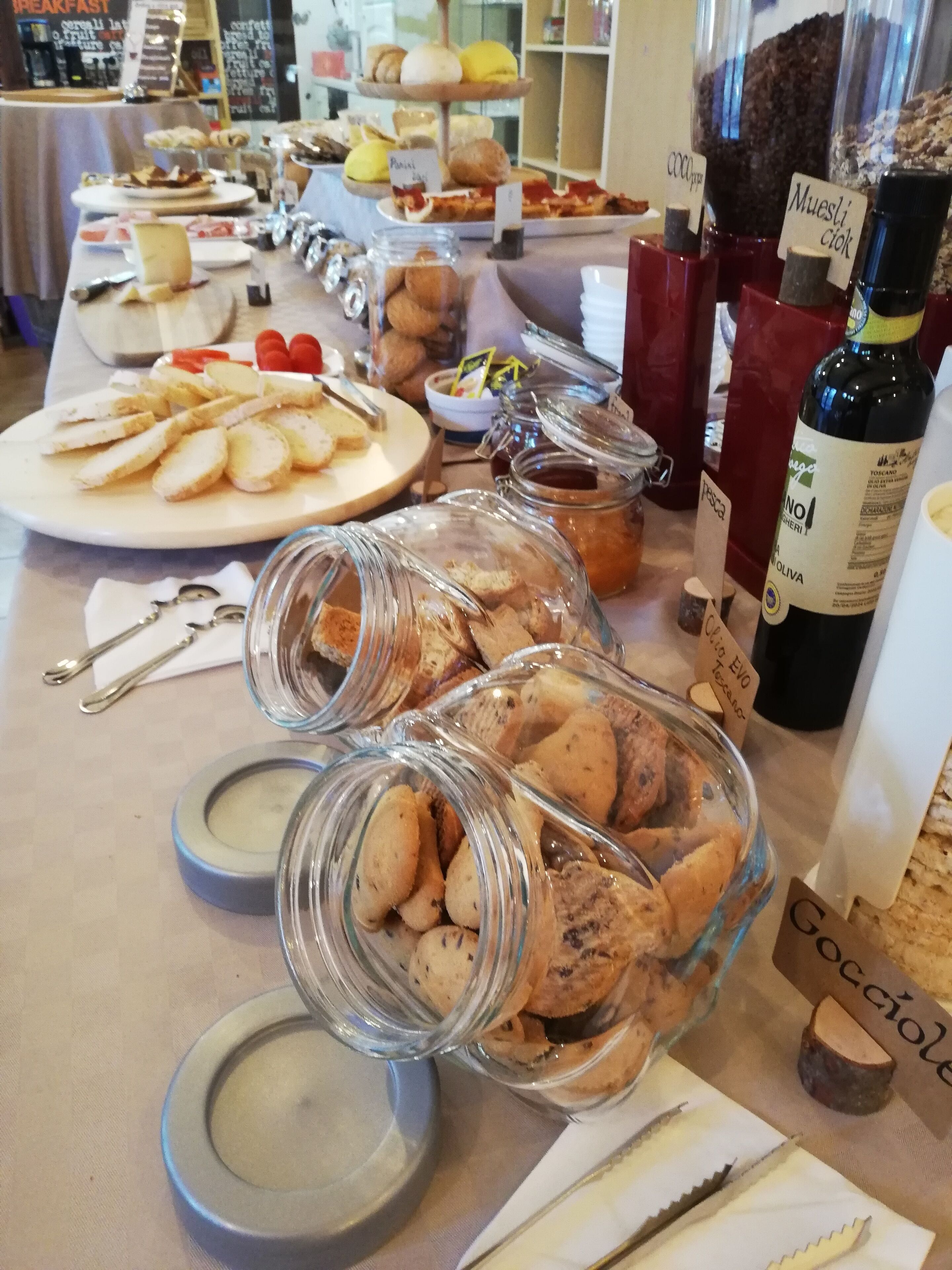 Uma mesa de buffet com diversos alimentos, incluindo pão, doces e acompanhamentos.