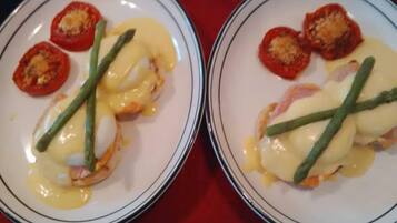 Duas porções de ovos Benedict com tomate e vagem.