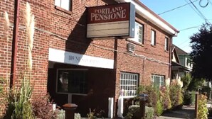 Um edifício de tijolos com uma placa que diz "Portland Pensione".