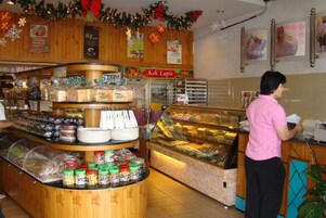 Uma área de buffet com diversos alimentos e uma placa indicando 'Kek Lapis'.