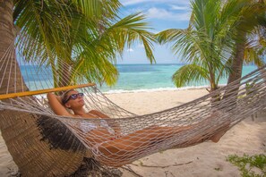 Na praia, areia branca, espreguiçadeiras 