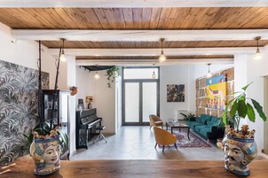 Uma sala de estar espaçosa com um piano, um sofá e uma mesa de centro.
