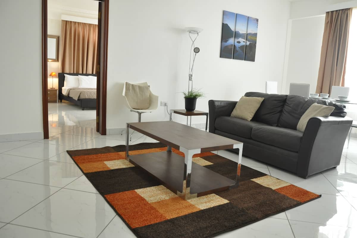 Uma sala de estar moderna com sofá, mesa de centro e luminária.