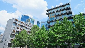 Um edifício moderno com vários andares, janelas amplas e varandas.
