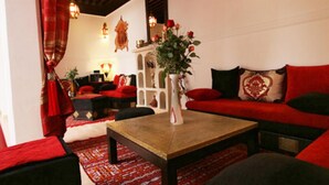Uma sala de estar aconchegante com um sofá vermelho, uma mesa de centro de madeira e um tapete estampado.