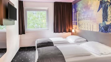 Quarto de hotel com duas camas, uma televisão, uma janela com cortinas e um mural na parede.