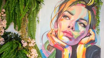 Uma pintura vibrante mostrando uma pessoa, rodeada por samambaias verdes exuberantes e flores cor-de-rosa.