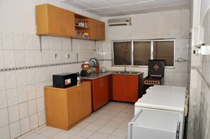 Apartamento, 2 quartos, vista para o pátio | Cozinha privada | Geladeira, micro-ondas, cooktop, cafeteira/chaleira