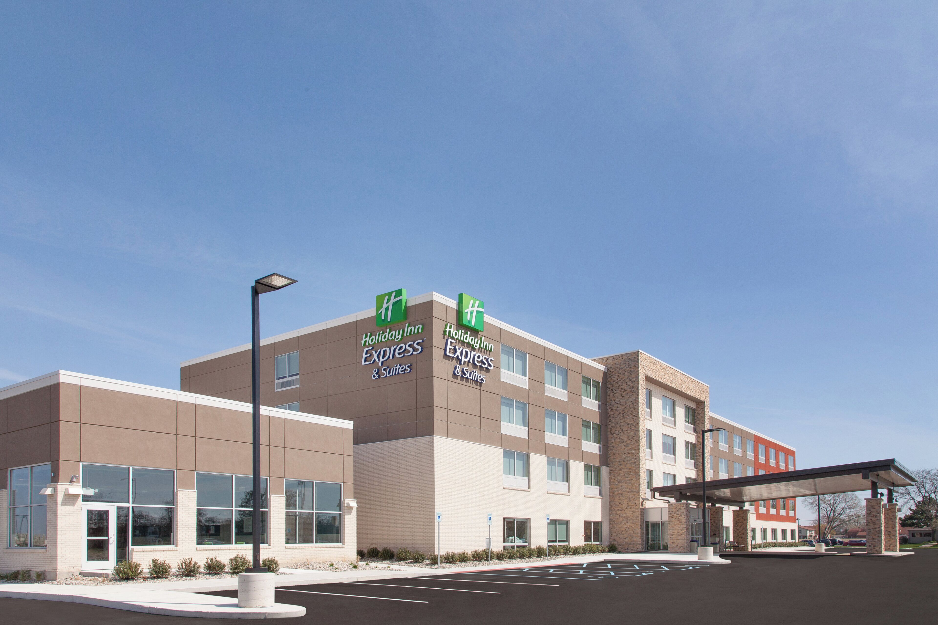 Um hotel Holiday Inn Express & Suites, com design moderno, fachada de tijolos e grandes janelas.