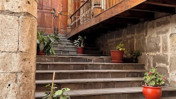 Uma escadaria de pedra com grades de madeira e plantas em vasos.