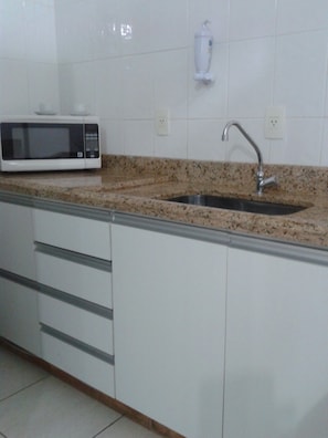 Um frigorífico, um micro-ondas (a pedido), uma placa de cozinha 