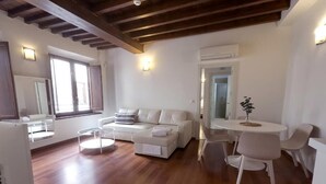 Uma sala de estar moderna com sofá, mesa de centro e área de jantar.