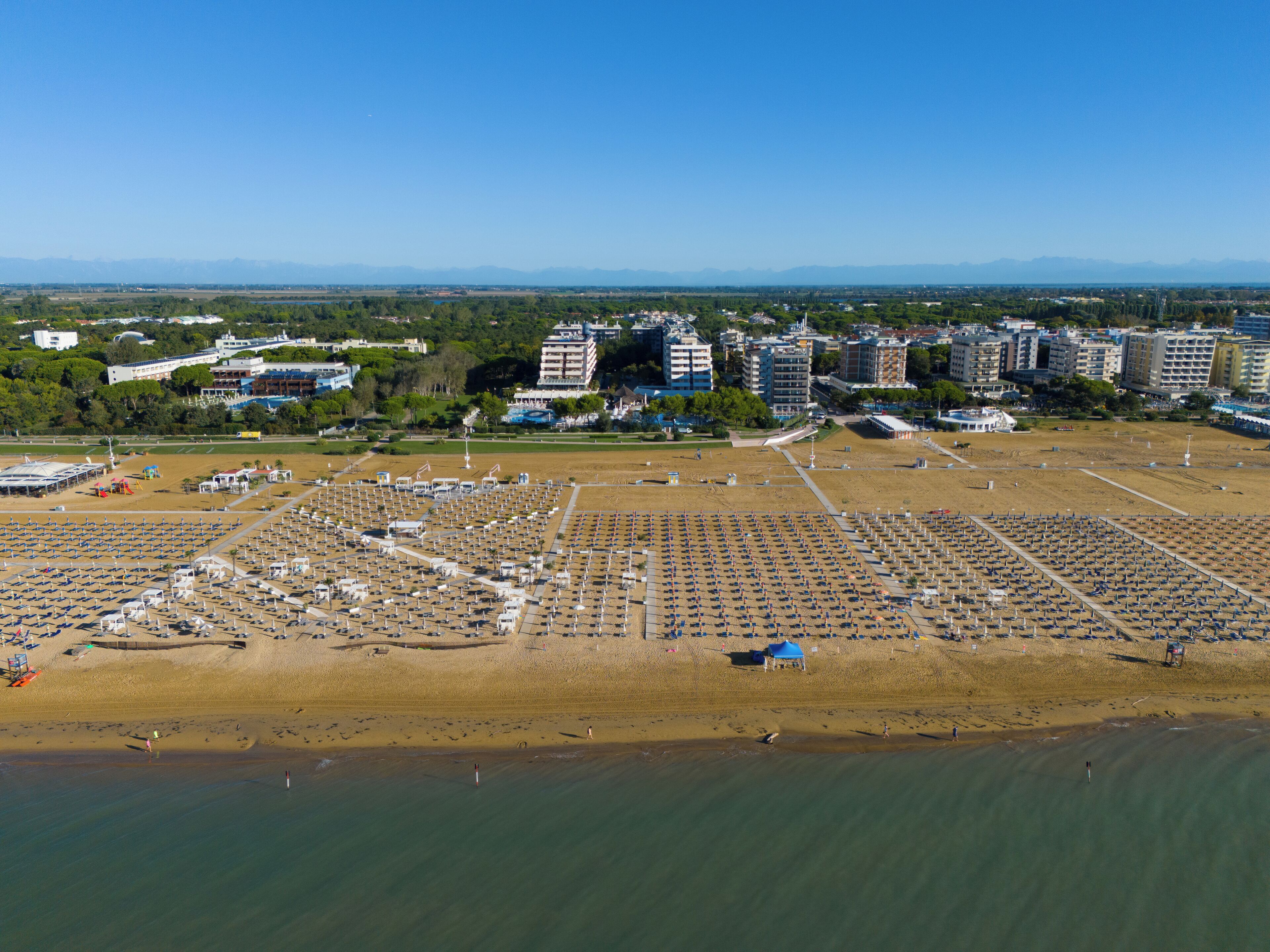 Na praia, espreguiçadeiras, guarda-sóis, toalhas de praia 