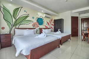 Quarto de hotel com uma cama grande, uma mesa de cabeceira de madeira, um guarda-roupa e uma cadeira.