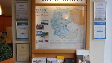 Um expositor emoldurado da AKZENT-HOTELS com um mapa, fotografias e prémios.