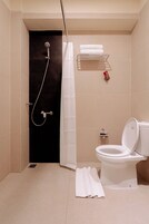 Uma casa de banho moderna com chuveiro, sanita e porta-toalhas.