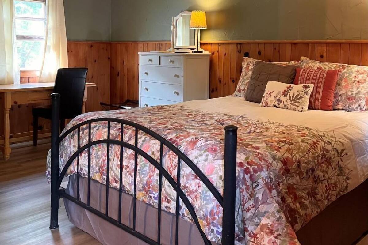 Quarto com uma cama, uma escrivaninha e uma cadeira.