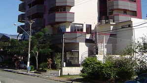 Um hotel de vários andares com um destaque para o letreiro 'HOTEL' na fachada, com varandas e uma entrada central.