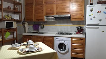 Um frigorífico/congelador grande, um micro-ondas, uma placa de cozinha